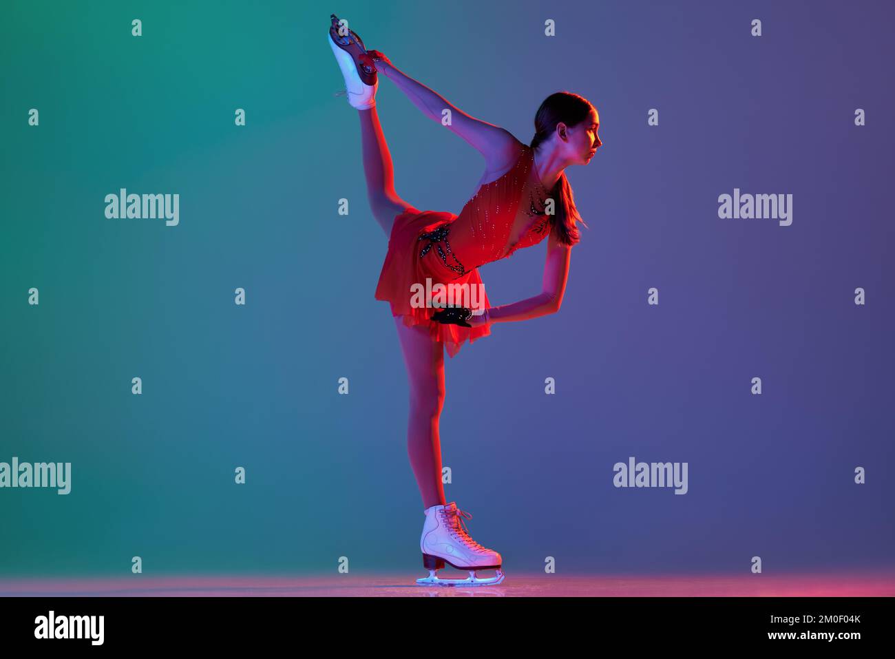 Winter sports. One junior female figure skater in red stage costume ...
