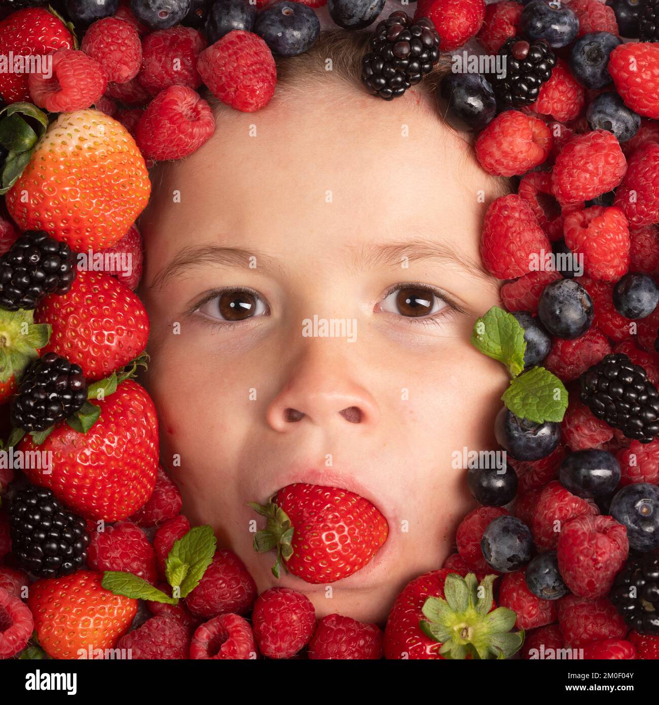 Strawberry, blueberry, raspberry, blackberry background on child face ...