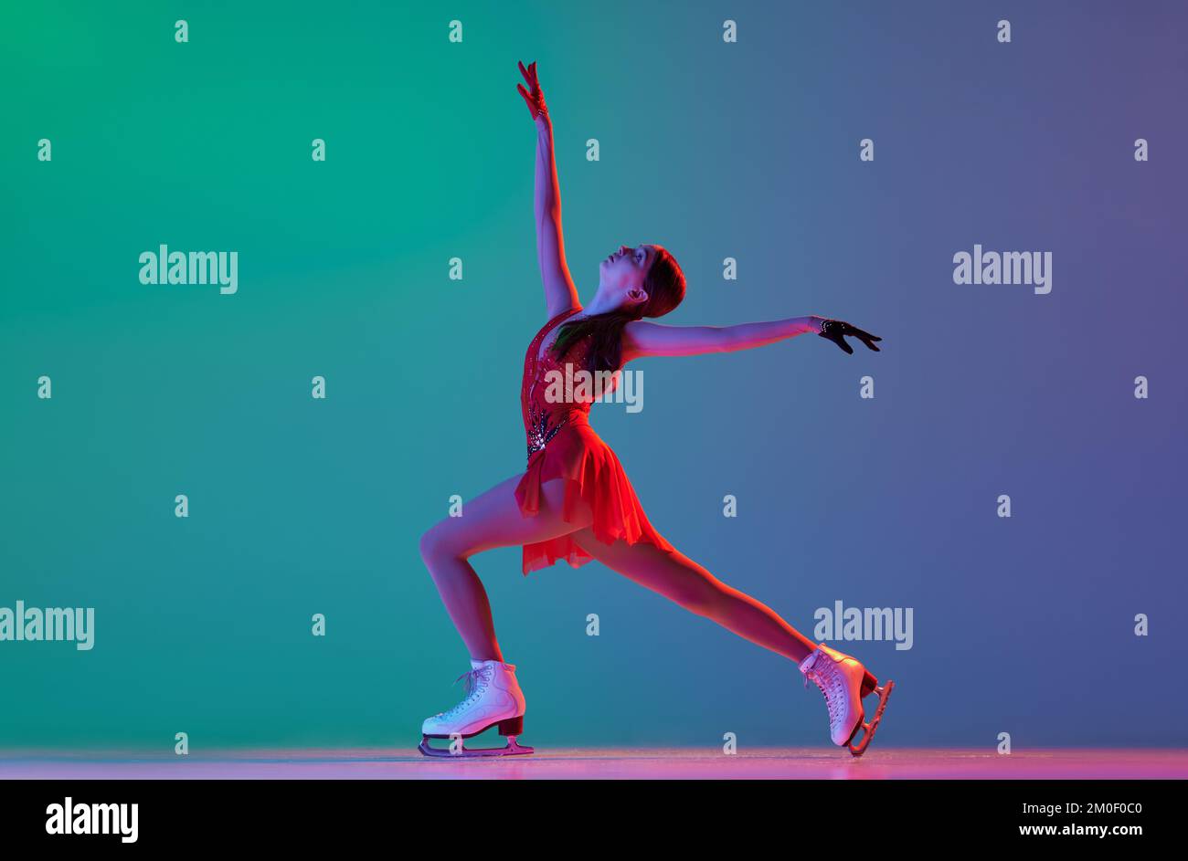 Winter sports. One junior female figure skater in red stage costume ...