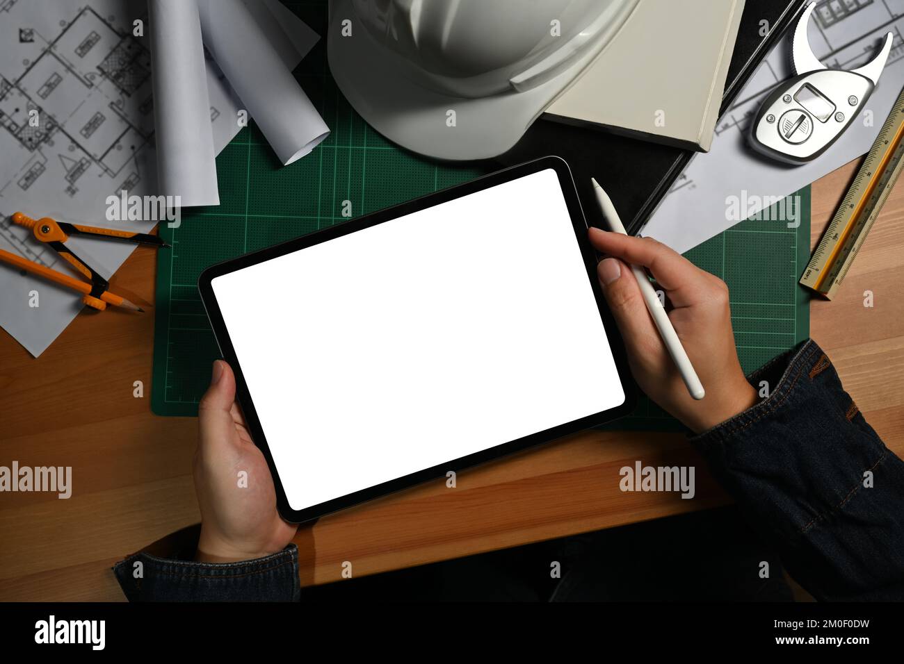 Engineer man using digital tablet and working with blueprints at ...