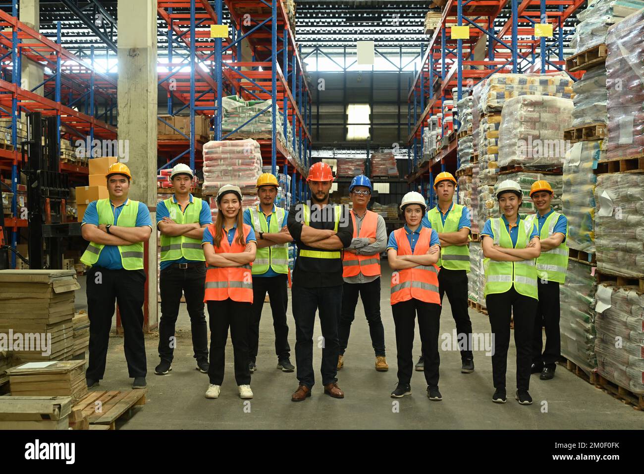 Group of warehouse worker standing in line with arms crossed together ...