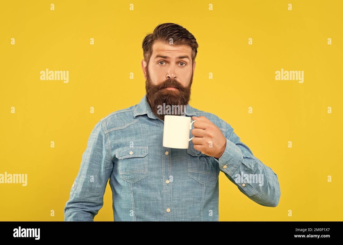 Surprised man holding tea mug yellow background, surprise Stock Photo ...