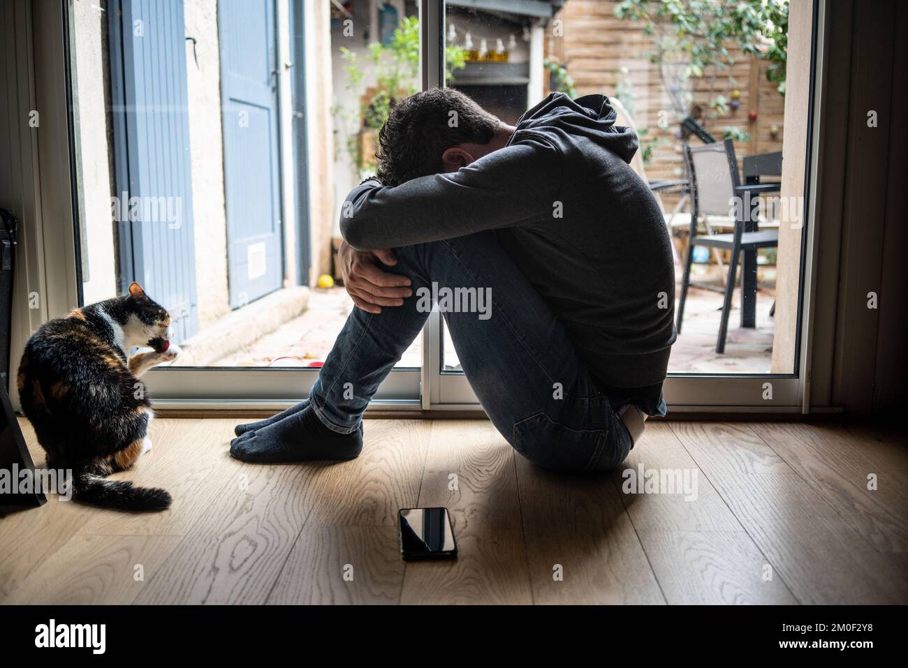 Depressed man. Sad unhappy Man sitting on the floor and holding his ...