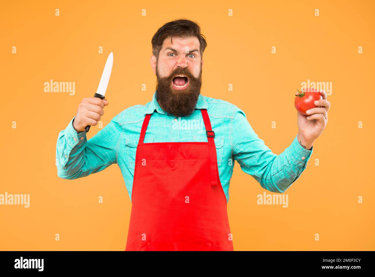 Hungry cook in apron hold tomato and knife for cooking healthy ...