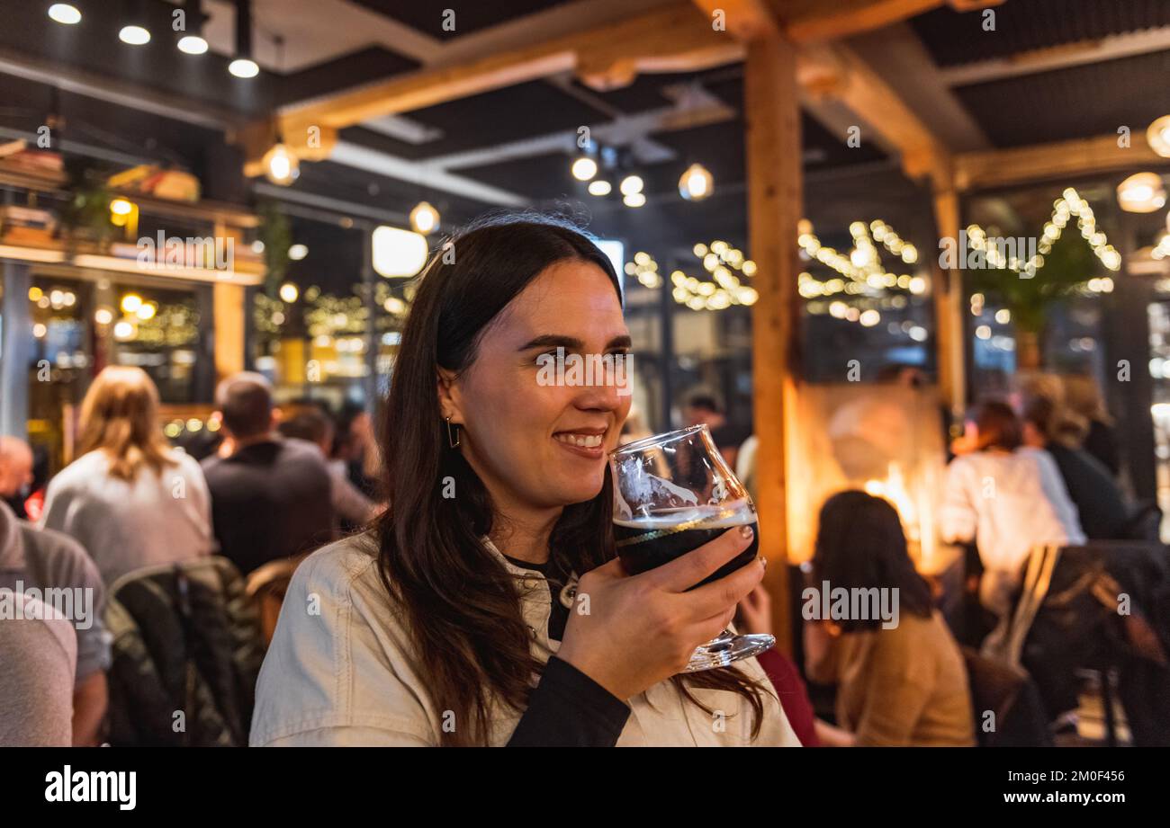 Beautiful girl drinking dark beer on a night out in bar Stock Photo - Alamy