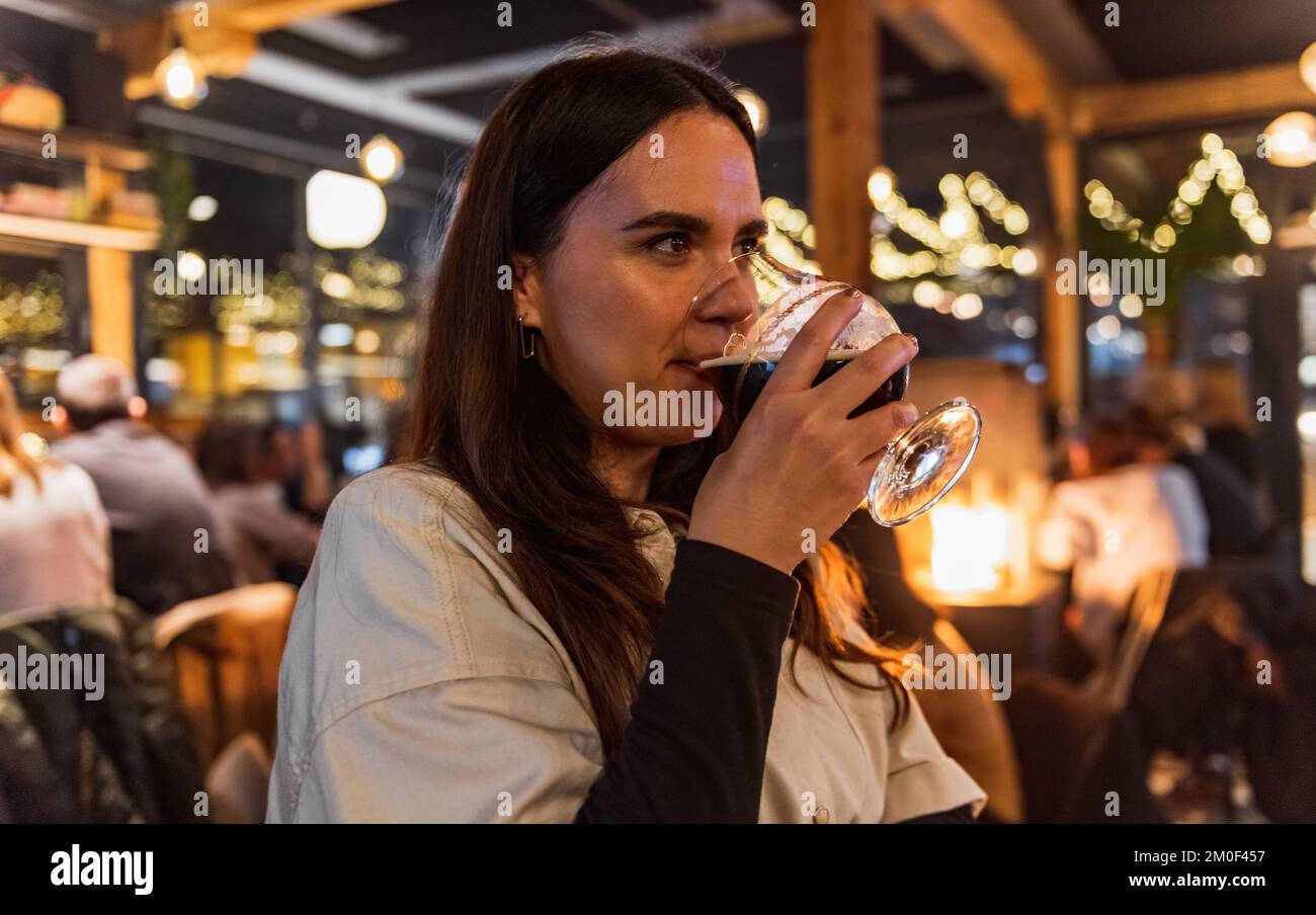 Beautiful girl drinking dark beer on a night out in bar Stock Photo - Alamy