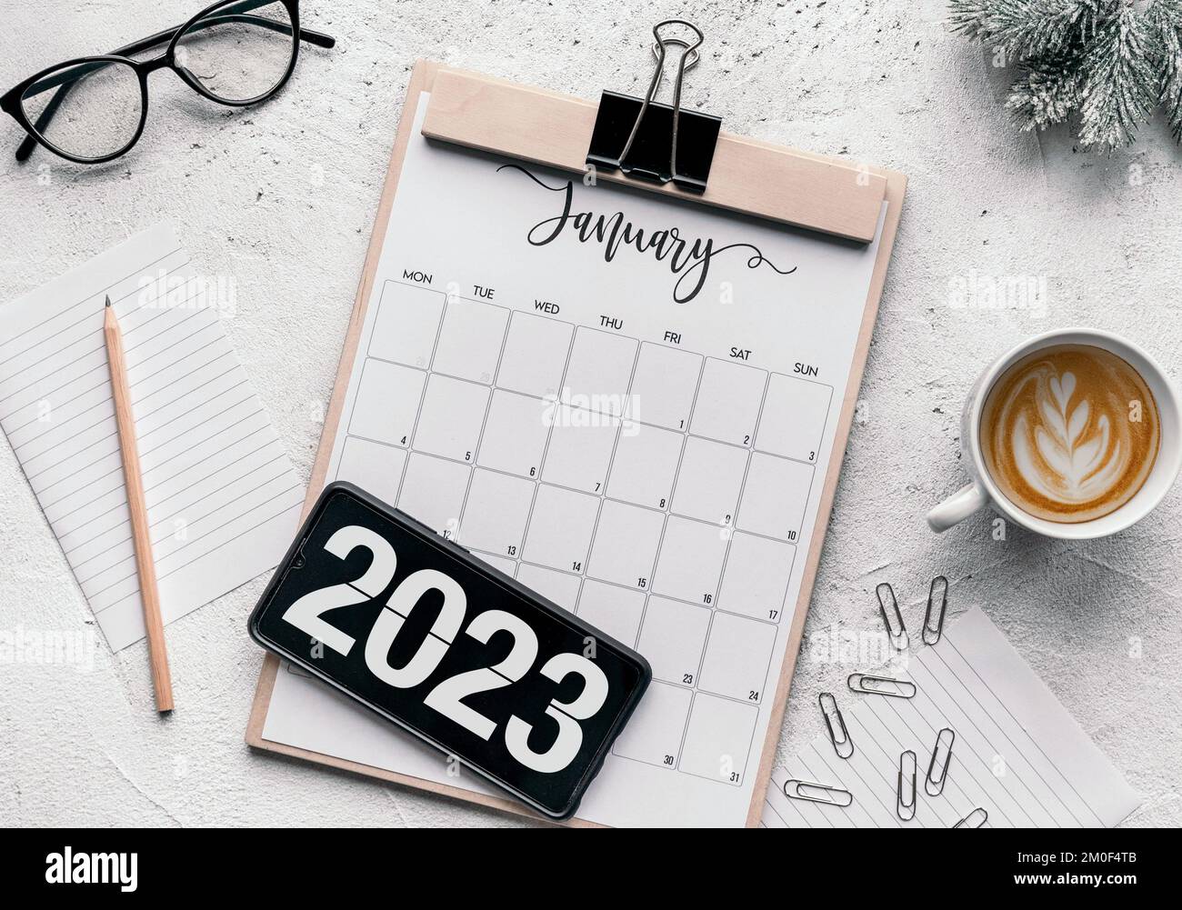 Top view of notepad with January 2023 calendar on table. Number 2023 on ...