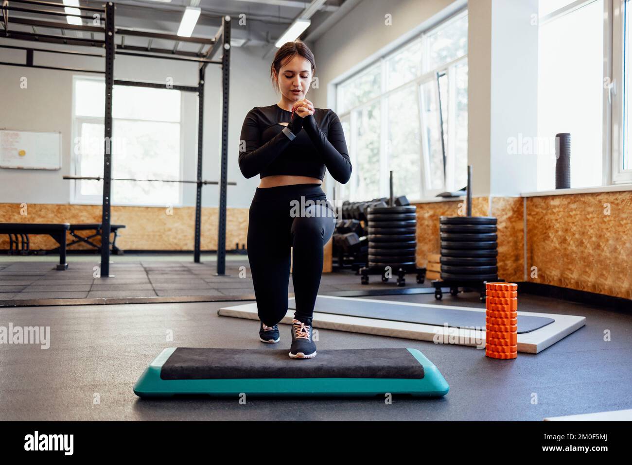 Fit young woman has training at a crossfit style on dark gray ...