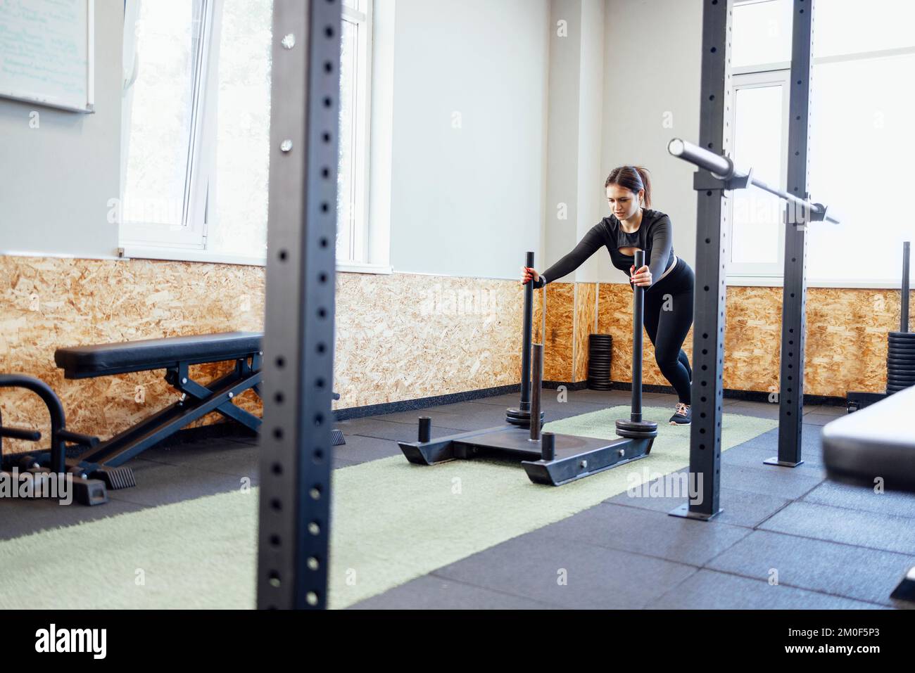 Fit young woman has training at a crossfit style on dark gray ...