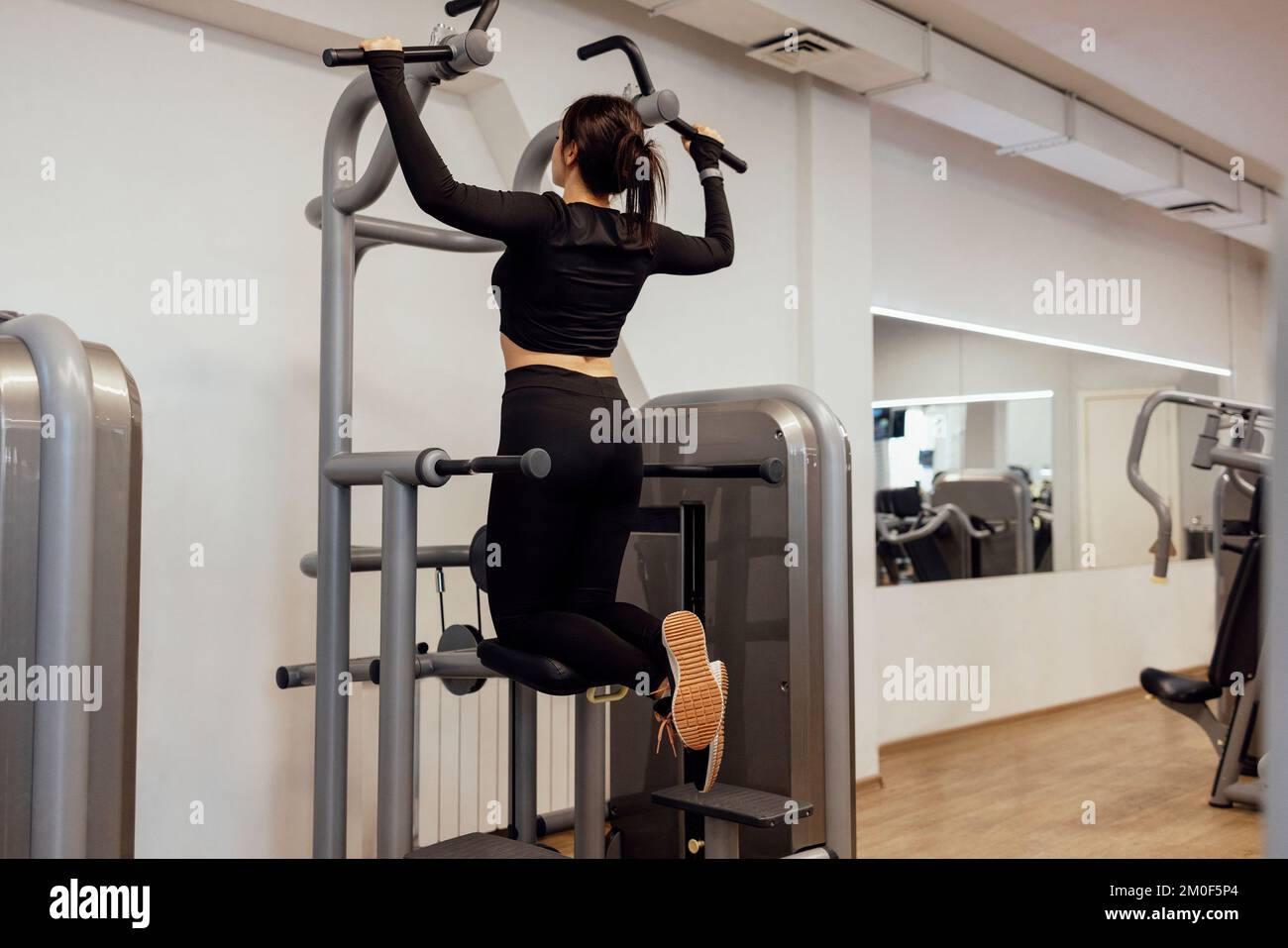 Attractive brunette sportive woman doing exercises on the simulator in ...