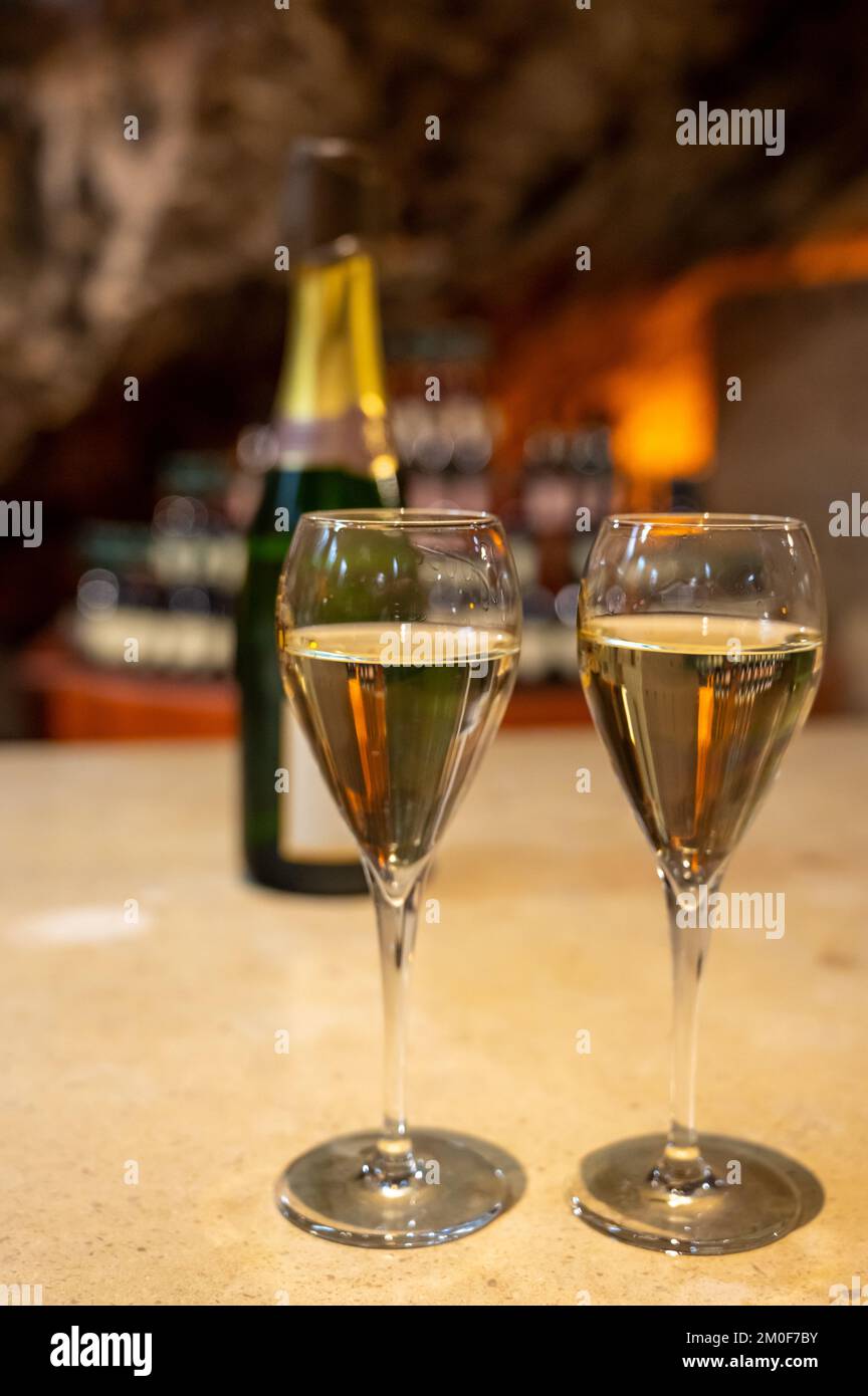 Tasting of rose champagne sparkling wine produced by traditional method in dark underground ...