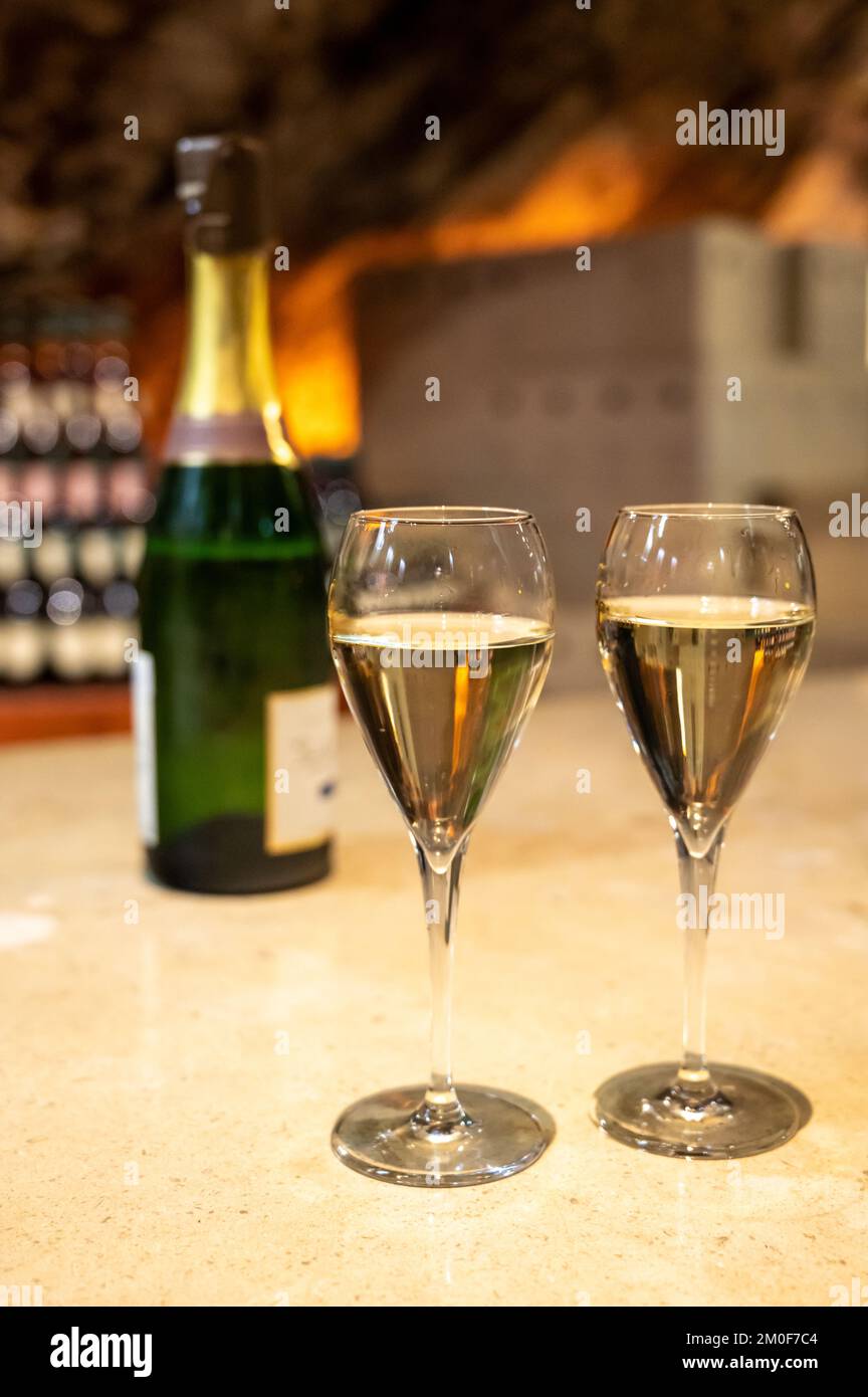 Tasting of rose champagne sparkling wine produced by traditional method in dark underground ...