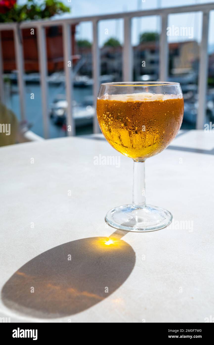 Glass of of French apple sparkling cider on plastic table in outdoor ...