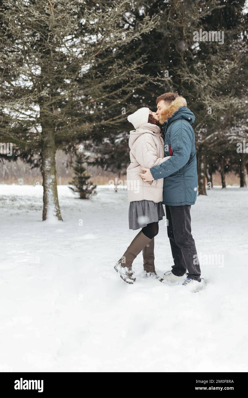 A couple is kissing in the snowy forest Stock Photo - Alamy