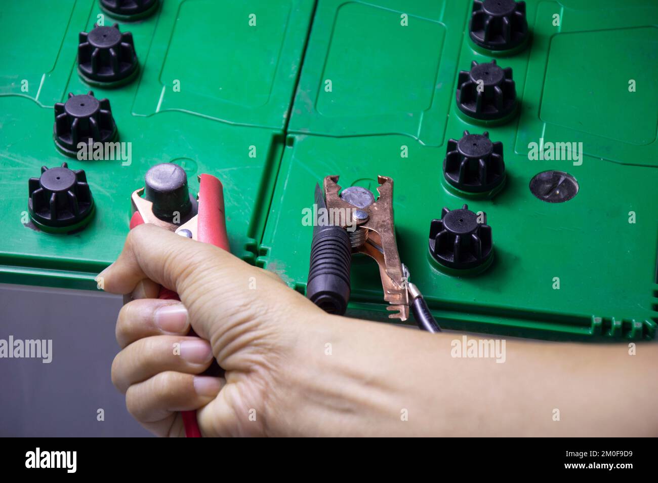 mechanic working with battery tweezers Stock Photo - Alamy