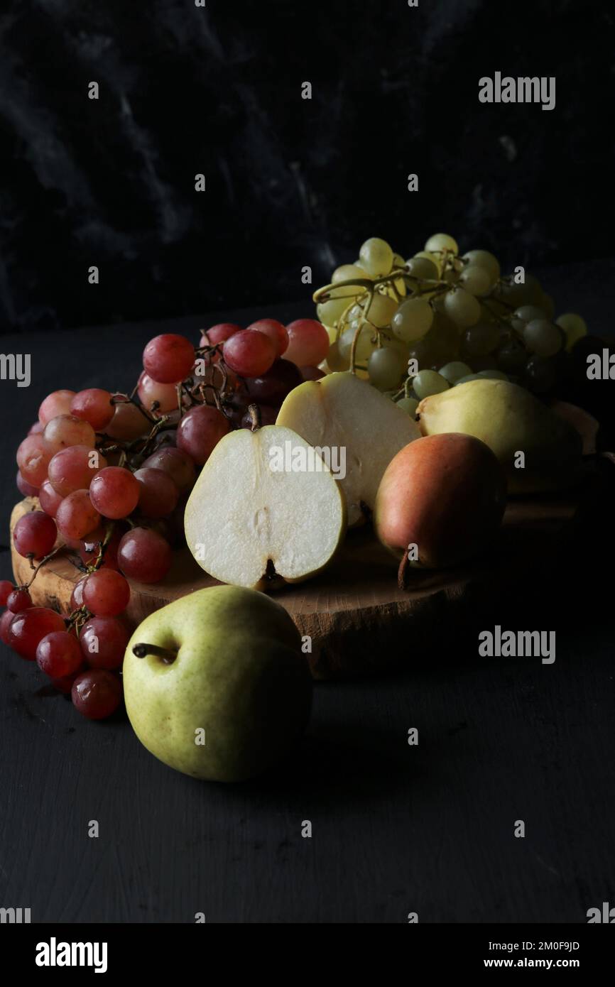 grape and pear fruits on a black background Stock Photo - Alamy