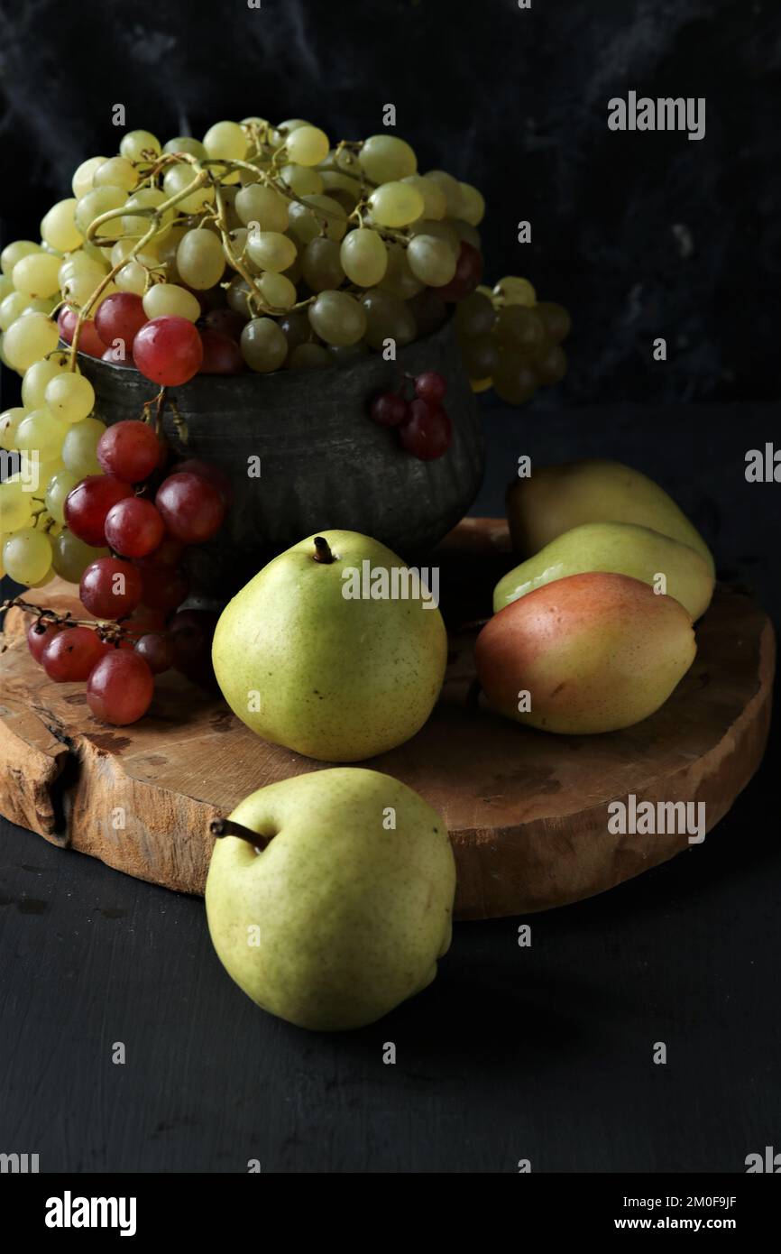 grape and pear fruits on a black background Stock Photo - Alamy