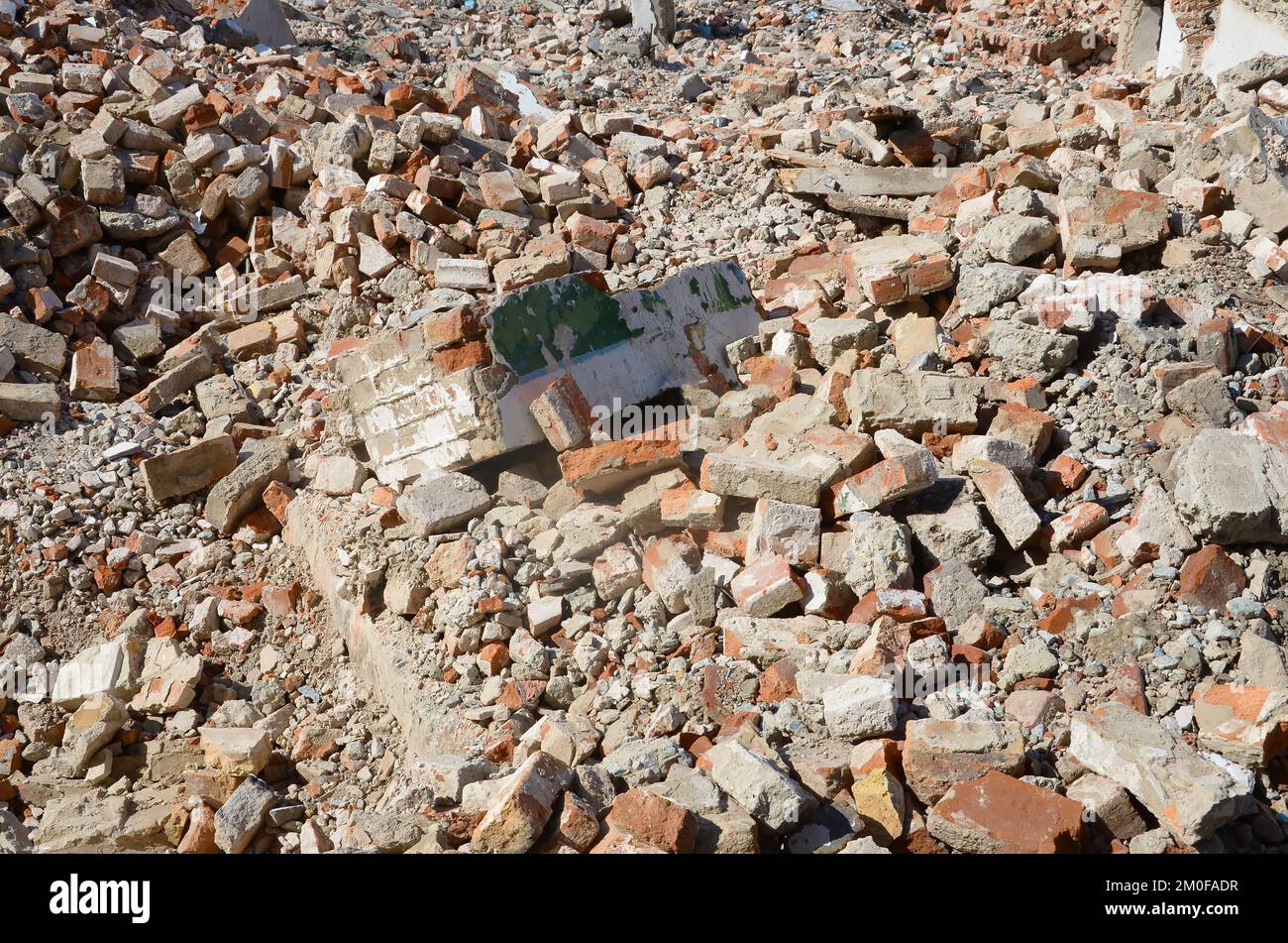 Pile of broken red bricks and fragments of concrete from destroyed building. Broken bricks close ...