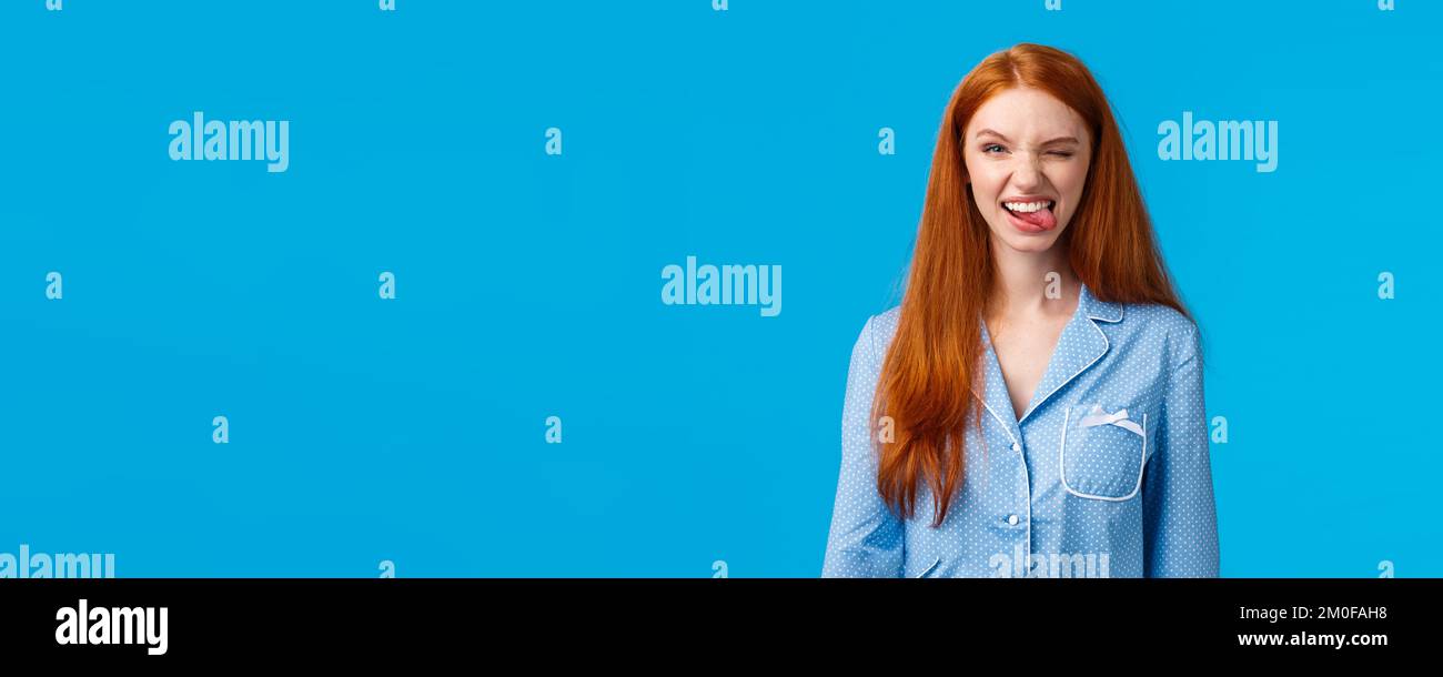 Sassy and excited good-looking redhead female in nightwear, winking ...