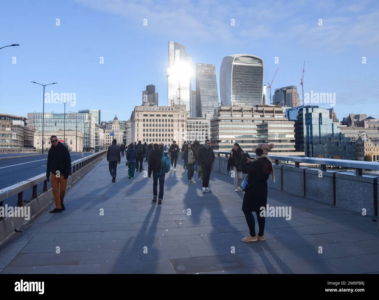 London, UK. 6th December 2022. People walk across London Bridge past ...