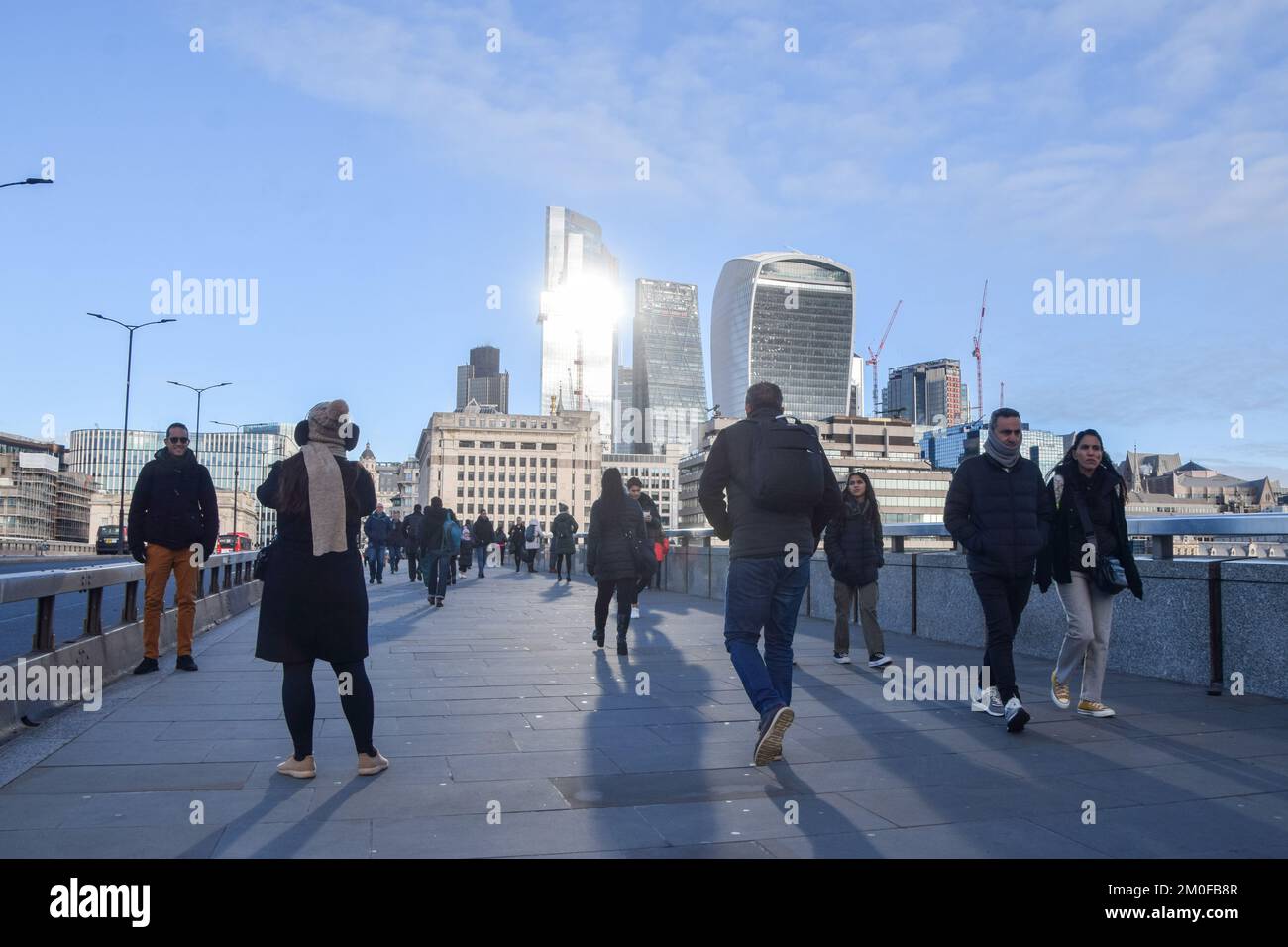 London, UK. 6th December 2022. People walk across London Bridge past ...