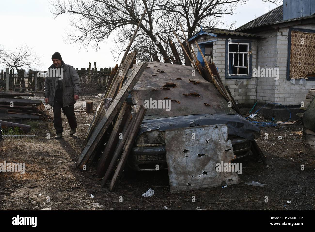 Zarichne, Ukraine. 24th Nov, 2022. A local resident walks past his car ...