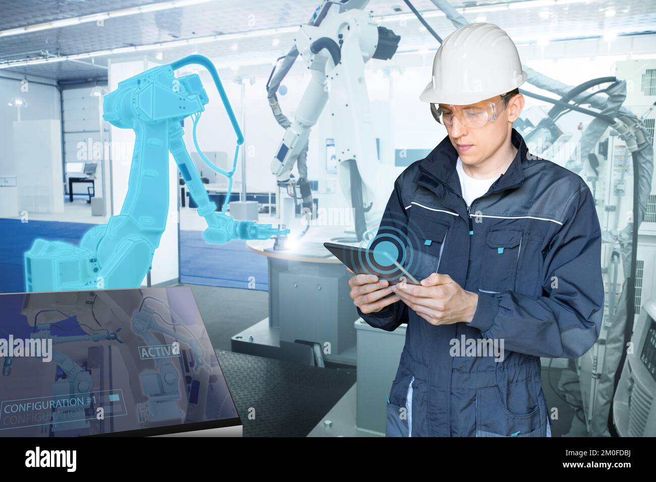 Engineer uses a digital tablet to control robots in a smart factory ...
