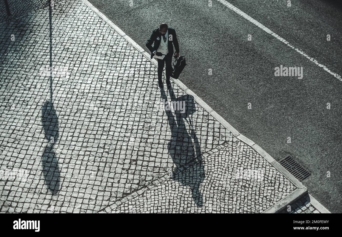 Drone view of a bald black man, dressed in a tie vest, on the edge of ...