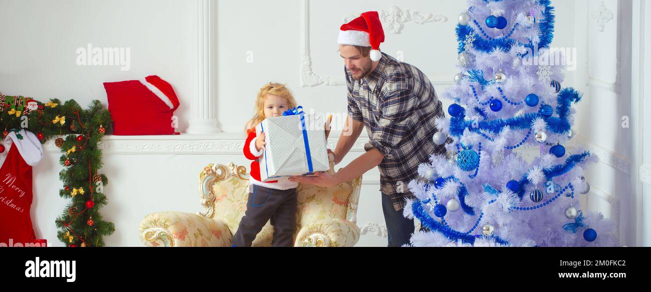 Brother with little child in Santa costume opening Christmas amazing ...