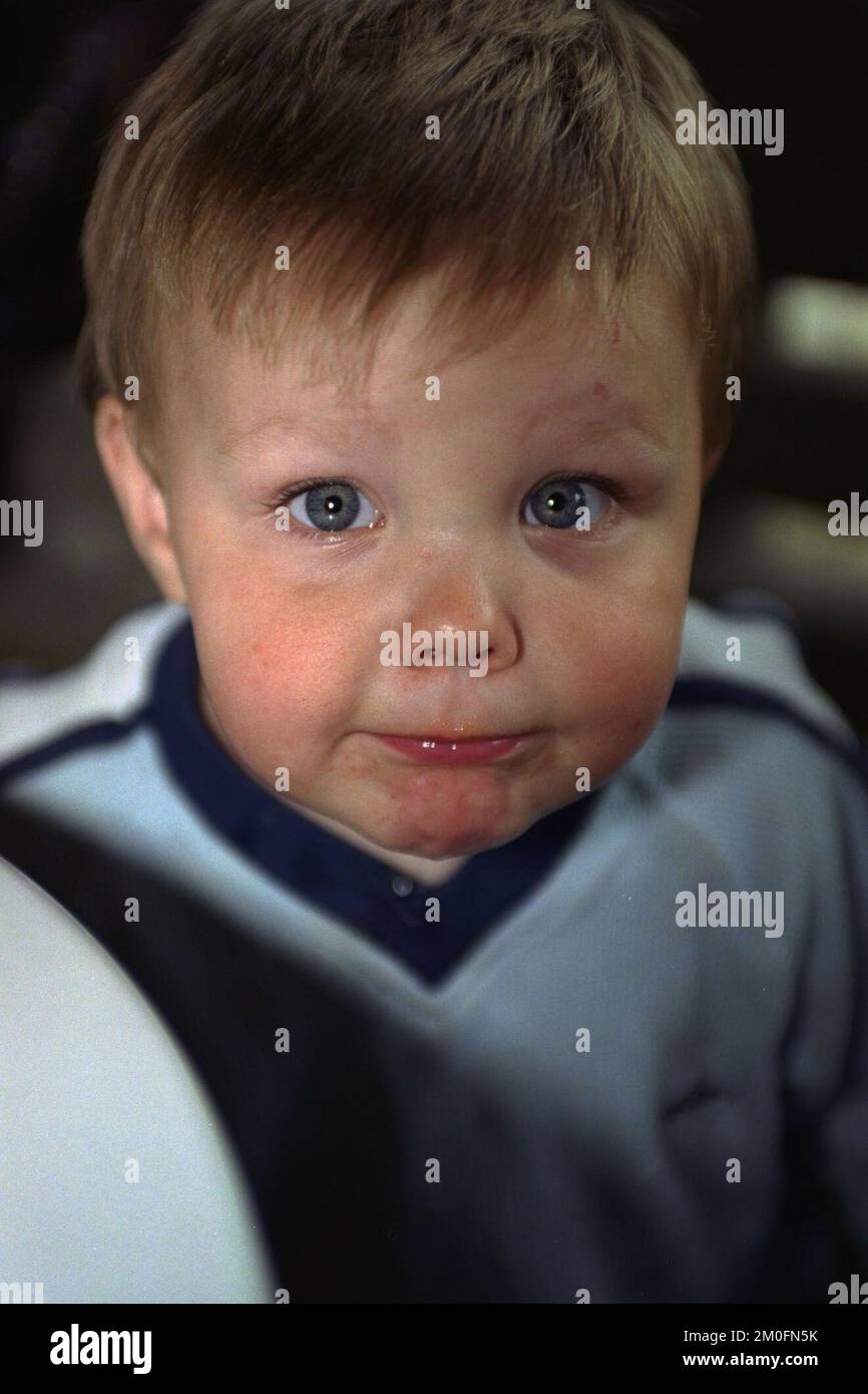 A little boy looking a bit sad, there are almost tears in his eyes ...