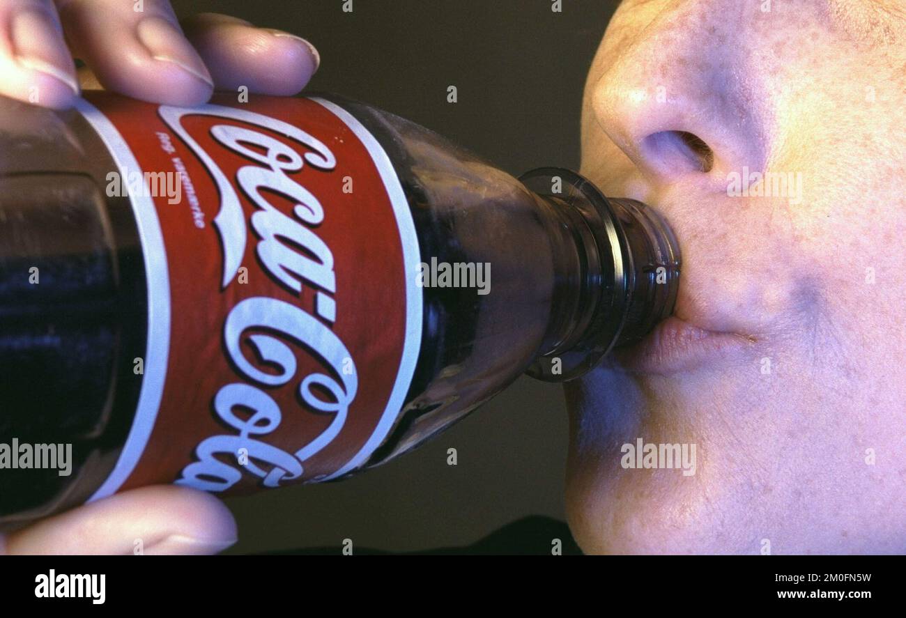 PA PHOTOS/POLFOTO - UK USE ONLY: A woman drinking Coca Cola from a bottle Stock Photo - Alamy