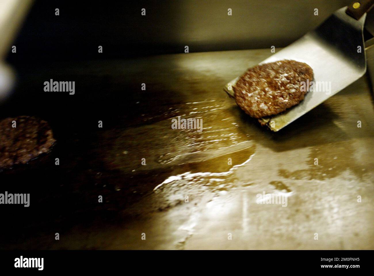 A hamburger is fried during an ordinary day at McDonalds in Copenhagen ...