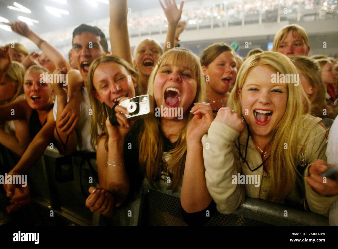 Fans scream as boy band Westlife perform on stage at the Forum ...