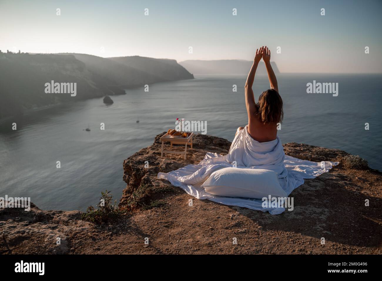 Woman wake up in bed wuth duvet and pillow over nature sea background ...