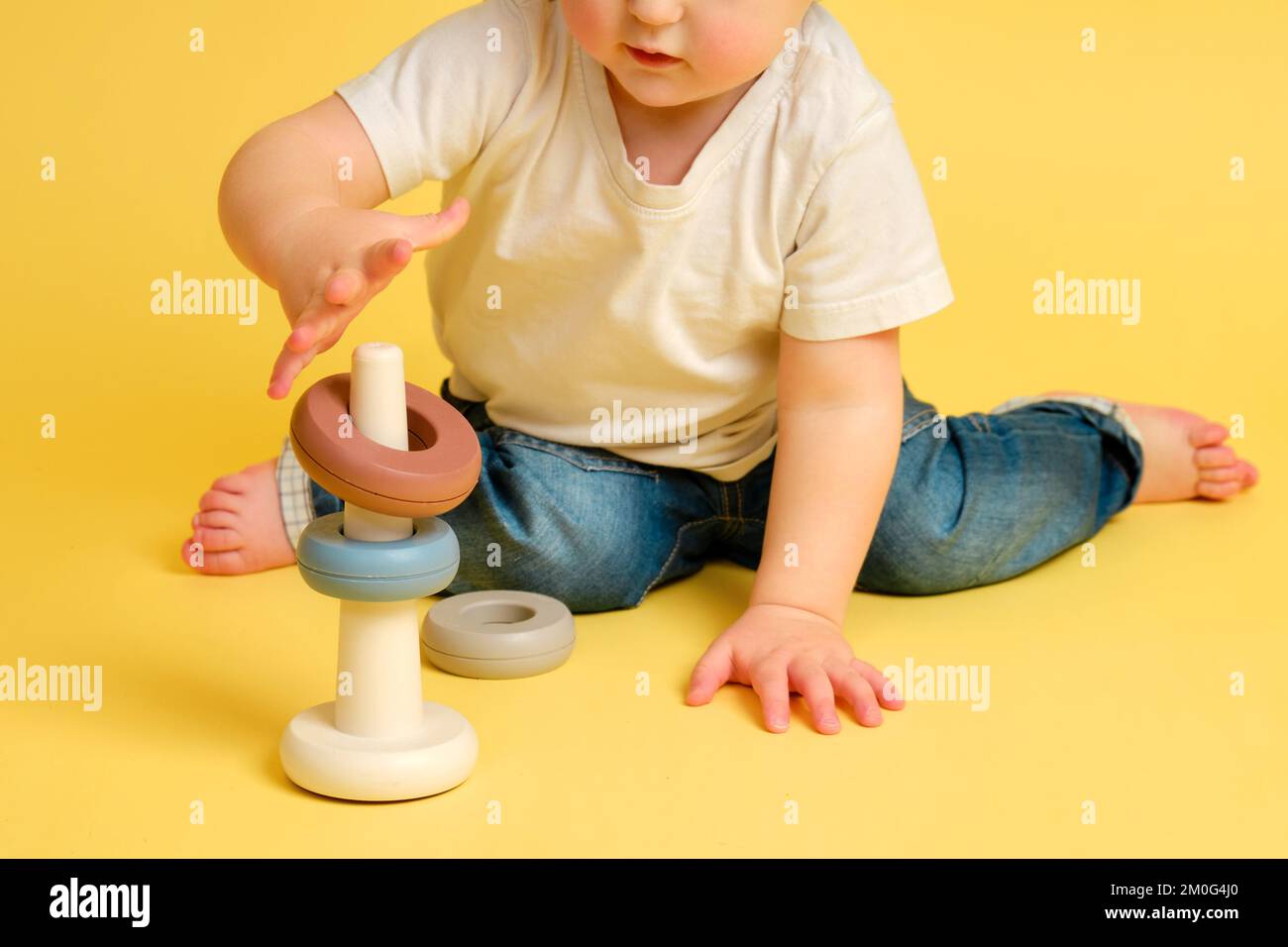 Toddler baby is playing logic educational games with a pyramid on a ...