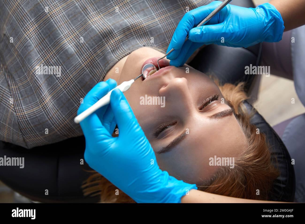 Dentist checking teeth of a female patient with dental mirror Stock ...