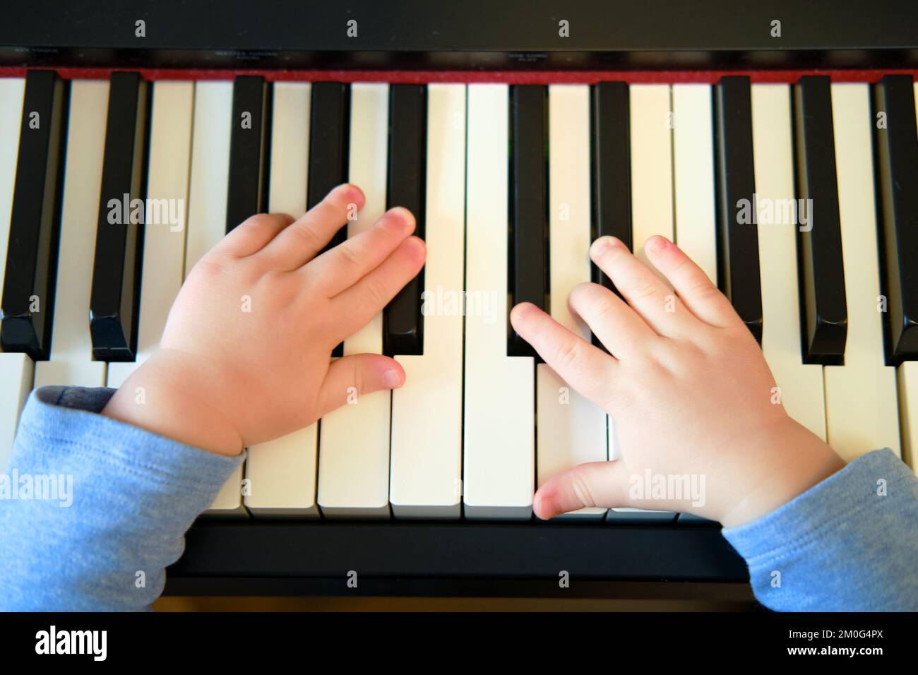 Toddler baby plays piano in home living room, music lessons. Happy ...