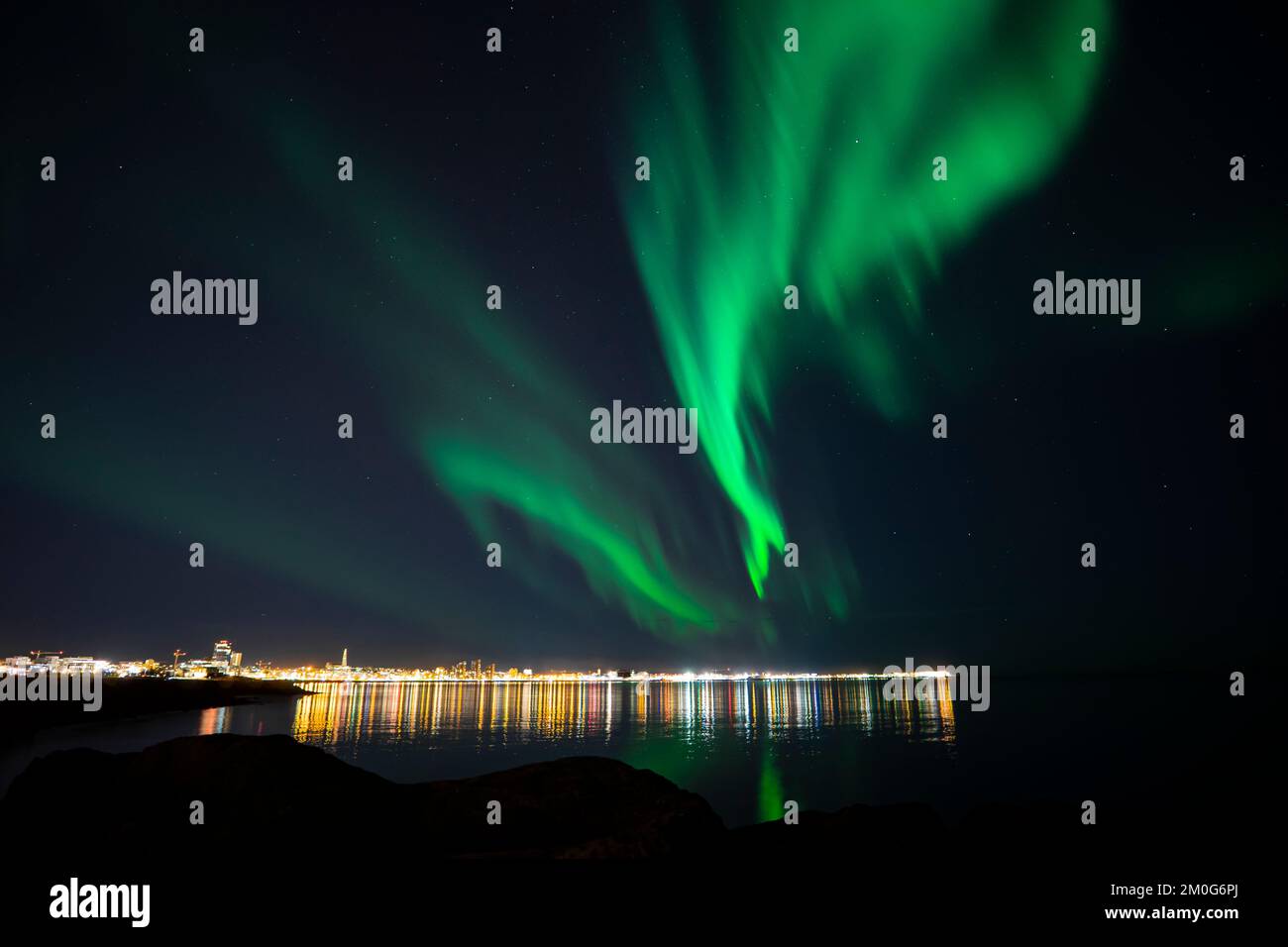 A low angle shot of the bright green northern lights over Reykjavik ...