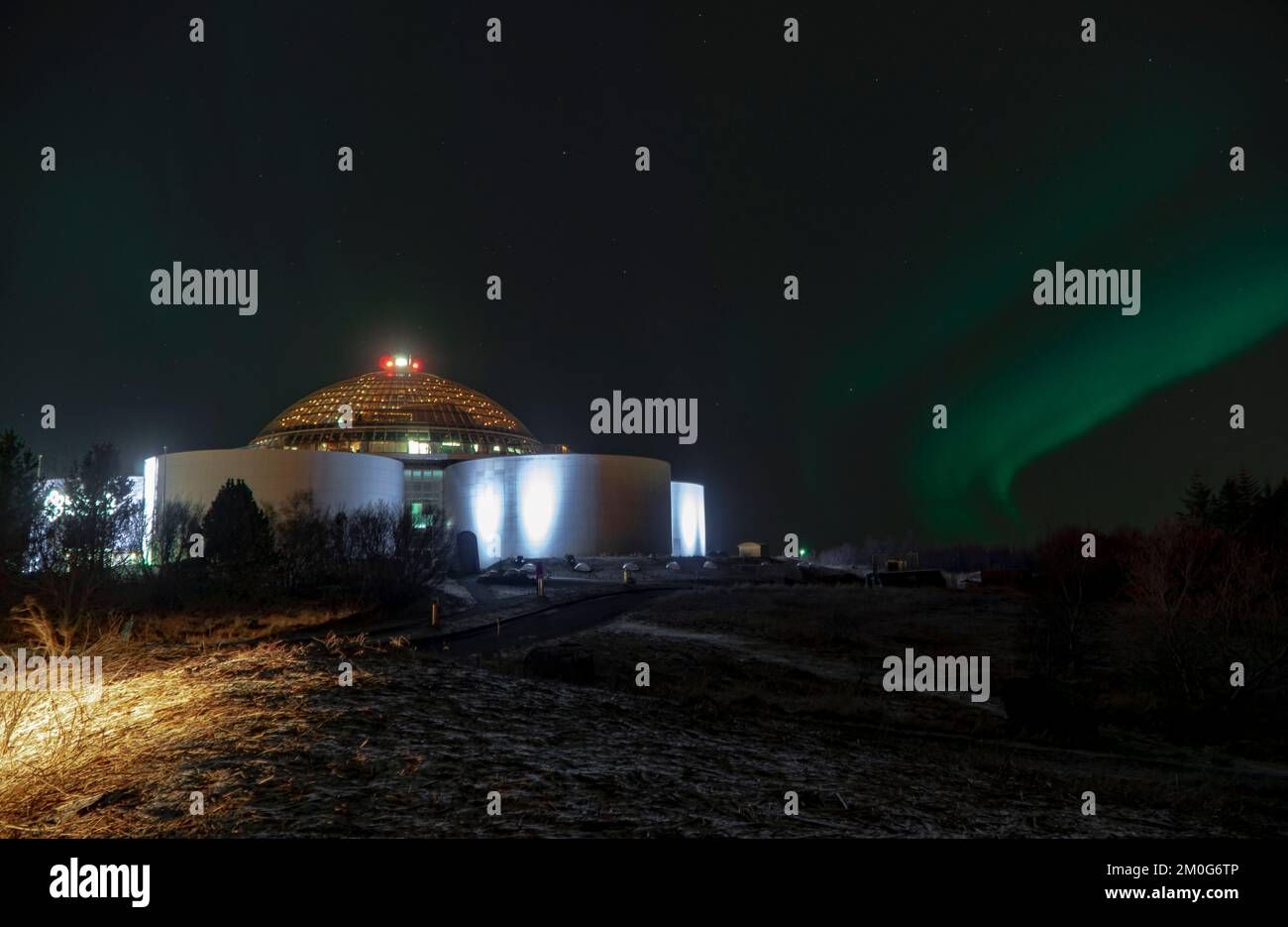 The green northern lights over the illuminated Perlan museum in ...