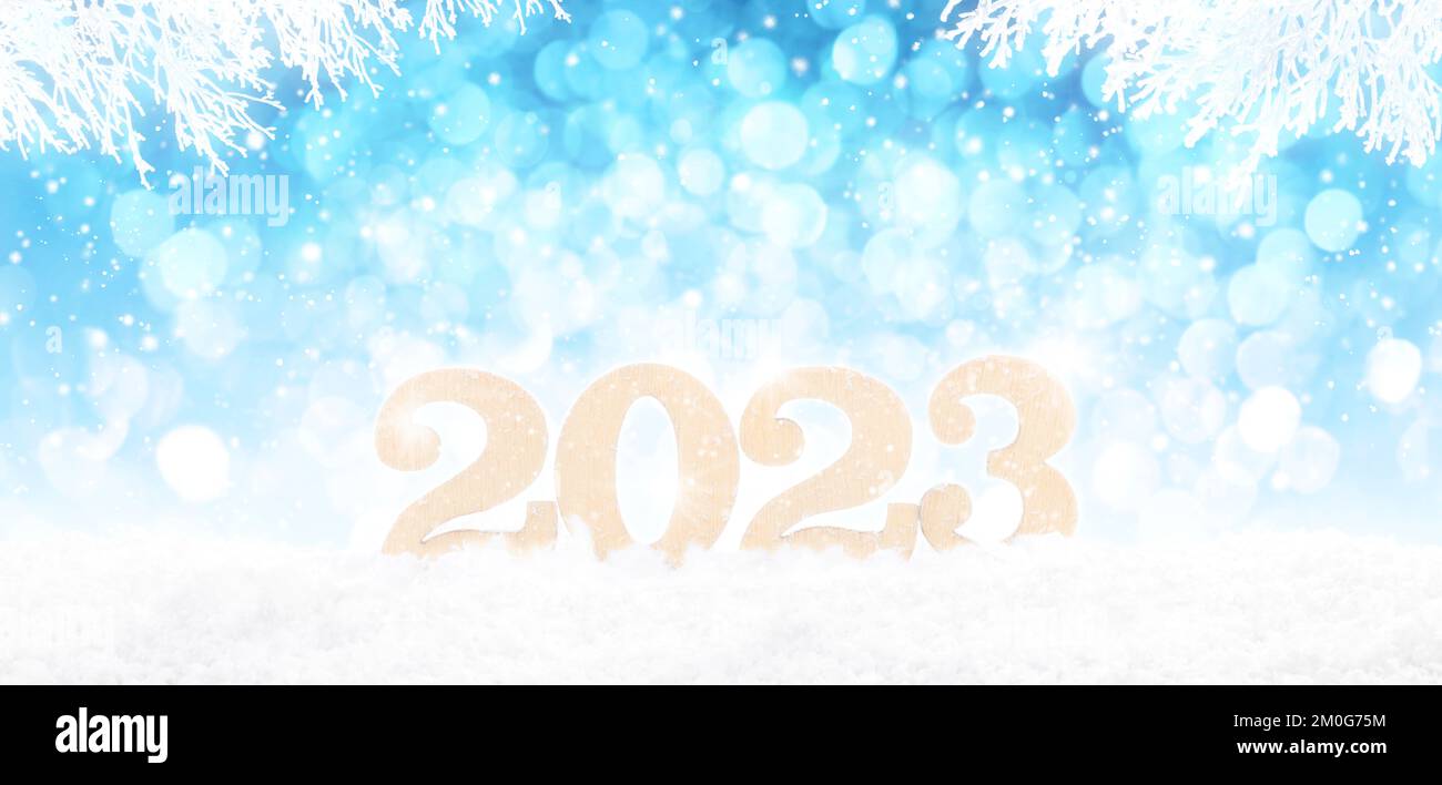 Wooden 2023 Numbers in perspective on bright blue bokeh winter background with white snowy ...