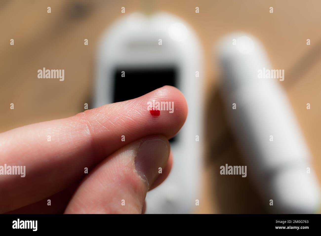 Woman pricking her finger to check blood glucose level with glucometer ...