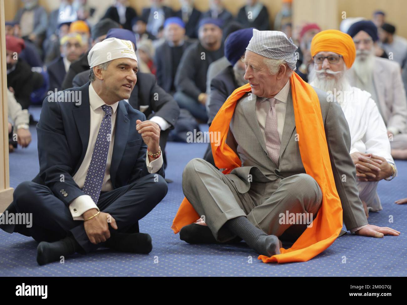 King Charles III sits on the floor in the Prayer Hall and speaks with ...