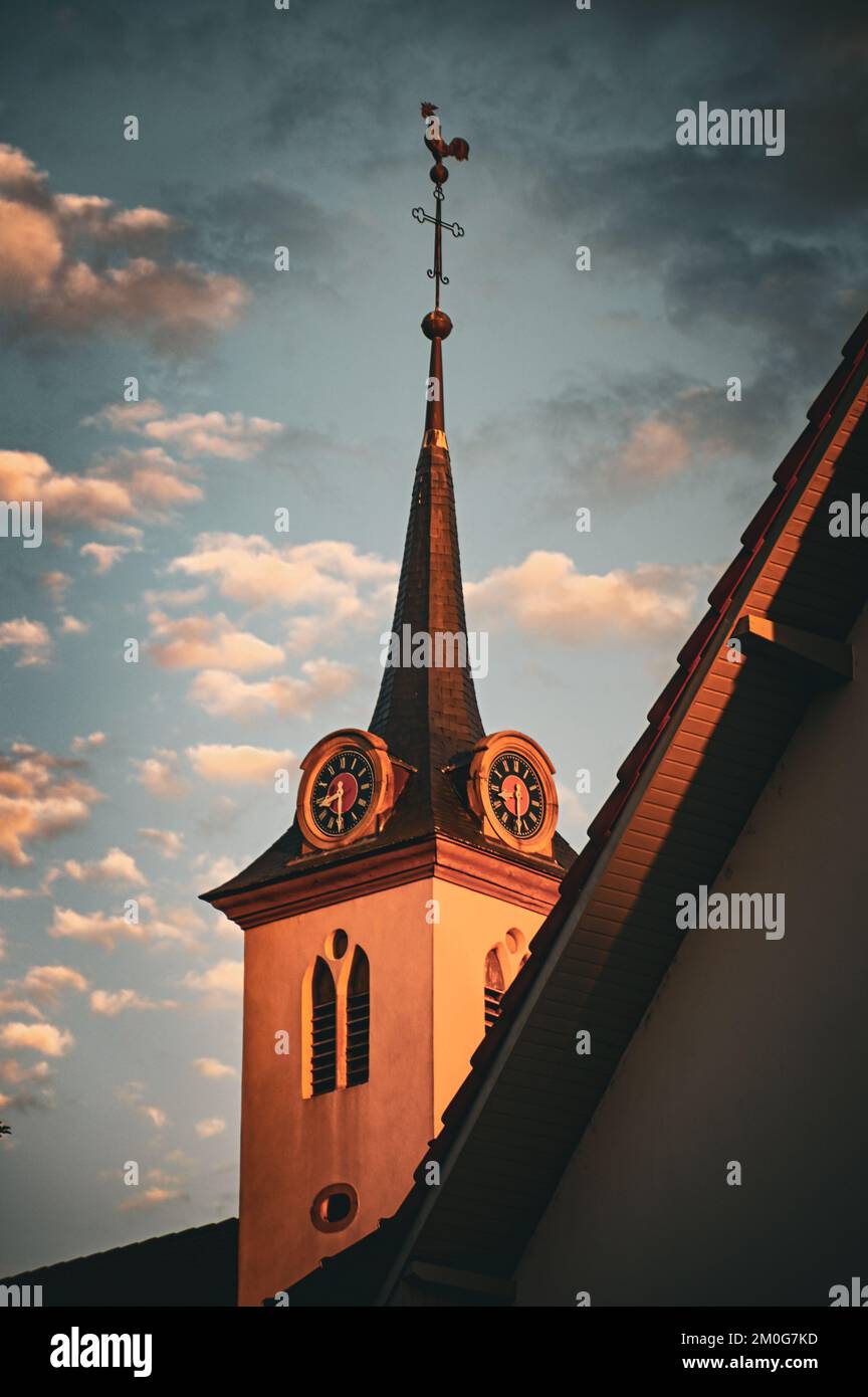 A vertical shot of a church building in Strasburg with a clock on its ...