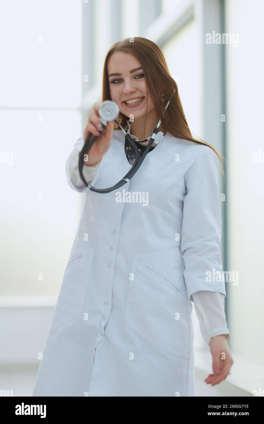 smiling female doctor with a stethoscope standing in the lobby of the ...