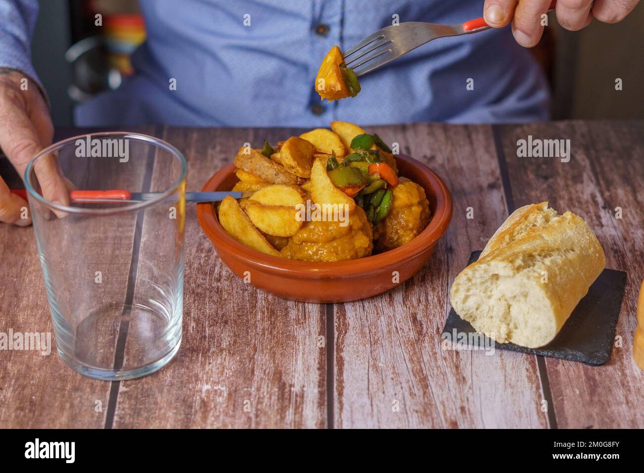 man with blue shirt eating meatballs with spaghetti in a restaurant ...