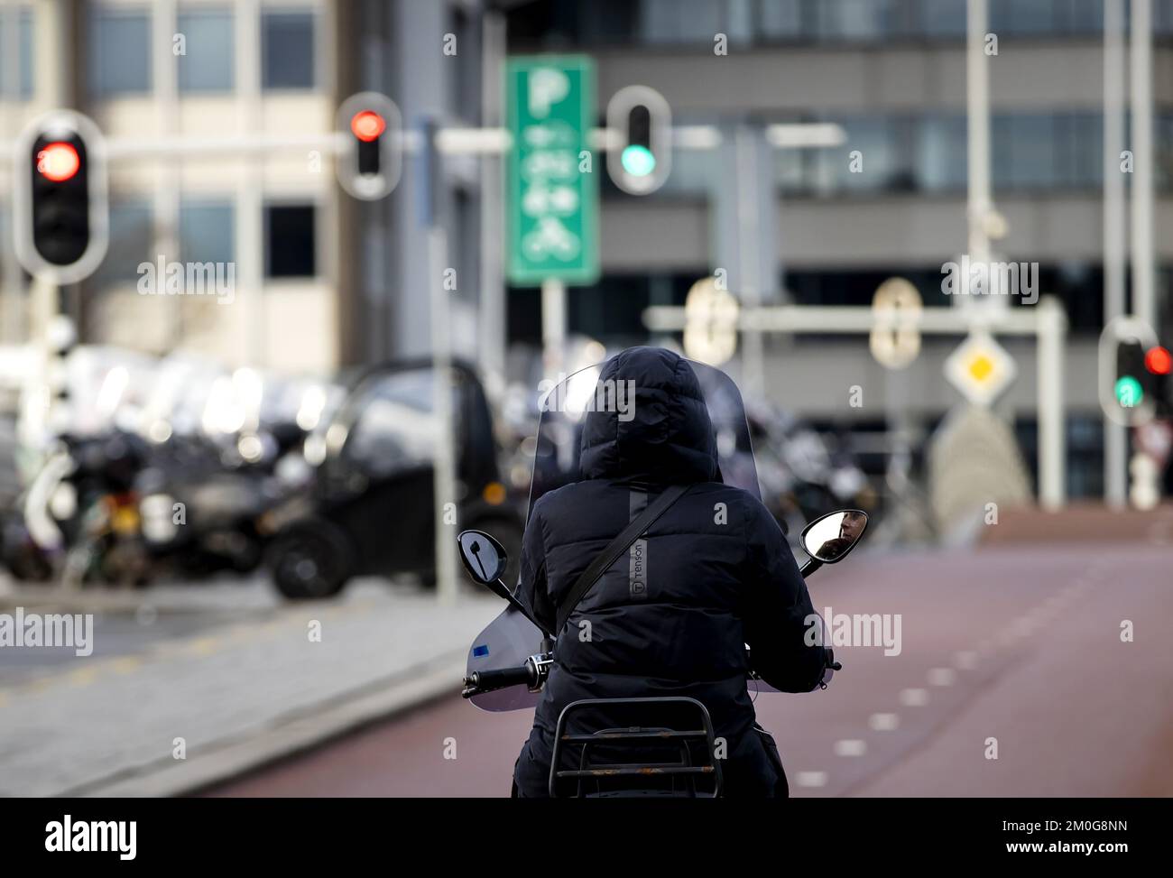 AMSTERDAM - A moped rider without a helmet in the center of Amsterdam ...