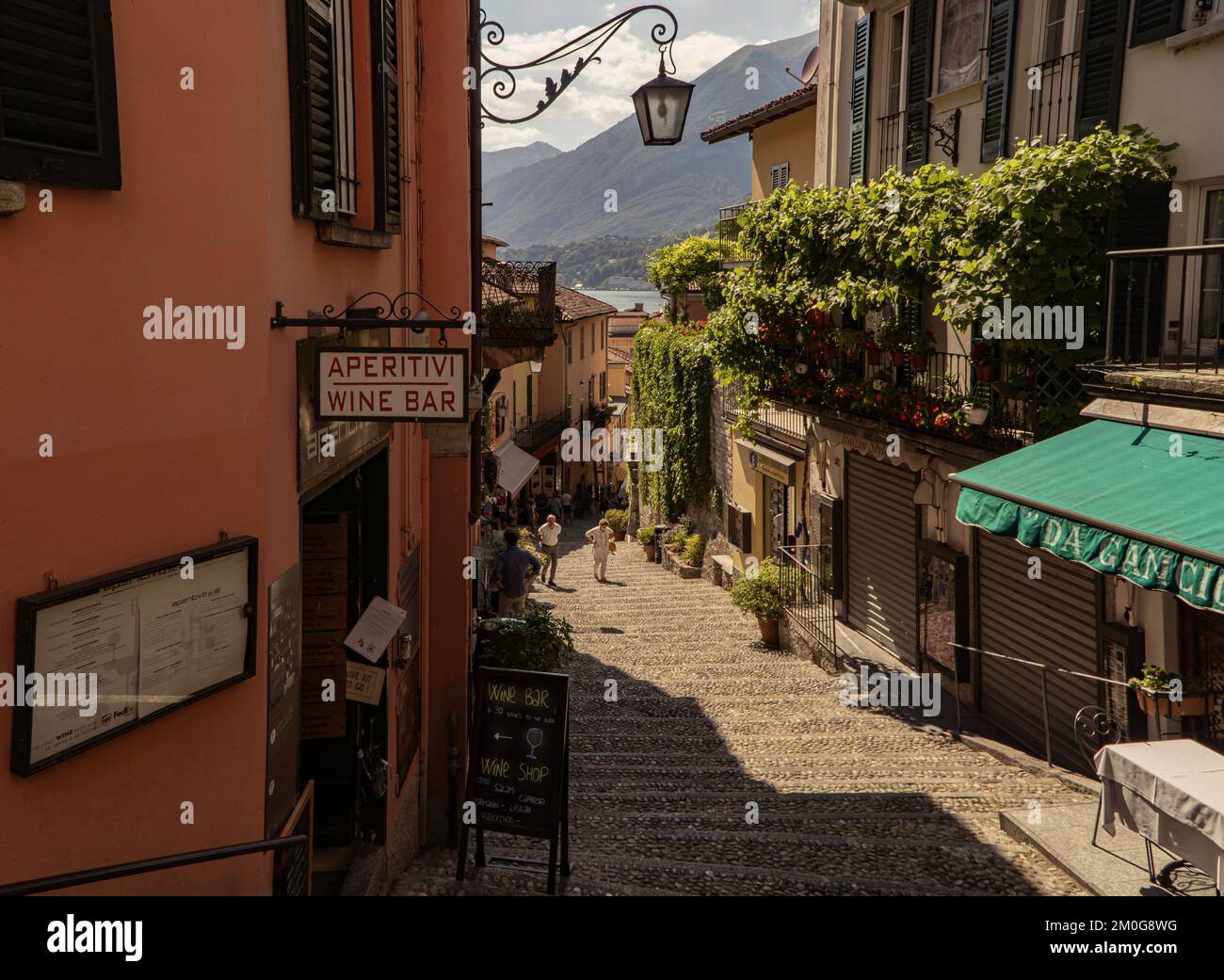 A beautiful rocky sunny alley with historic buildings in Bellagio near ...