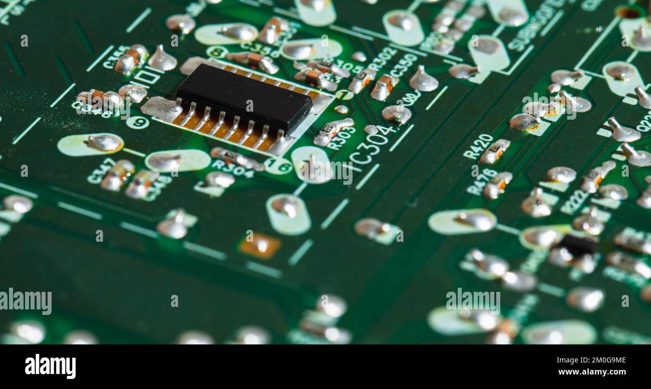Micro chip and capacitors mounted on a green printed circuit board ...