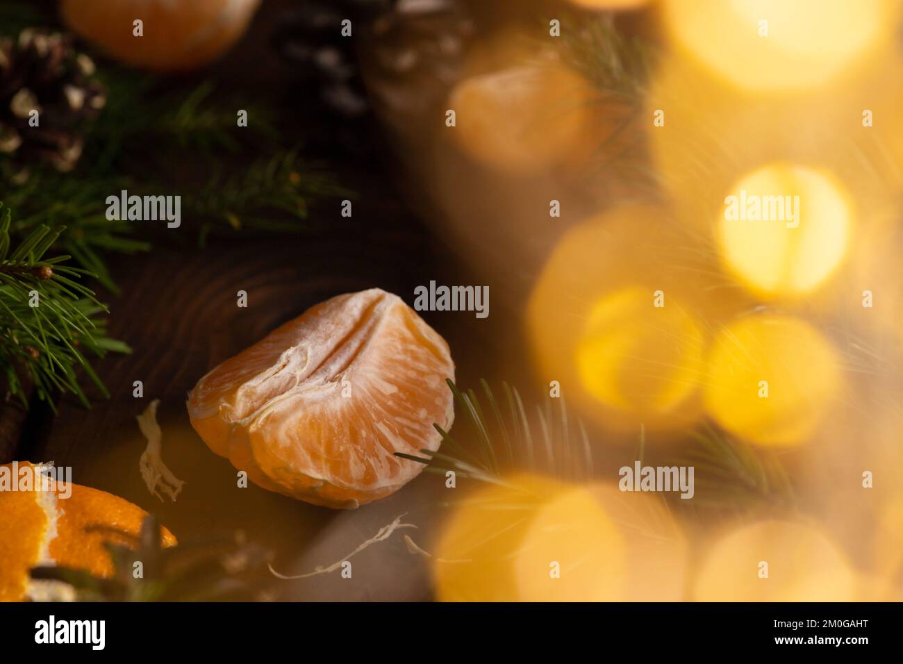 tangerine slices lie on a wooden table surrounded by spruce twigs Stock ...