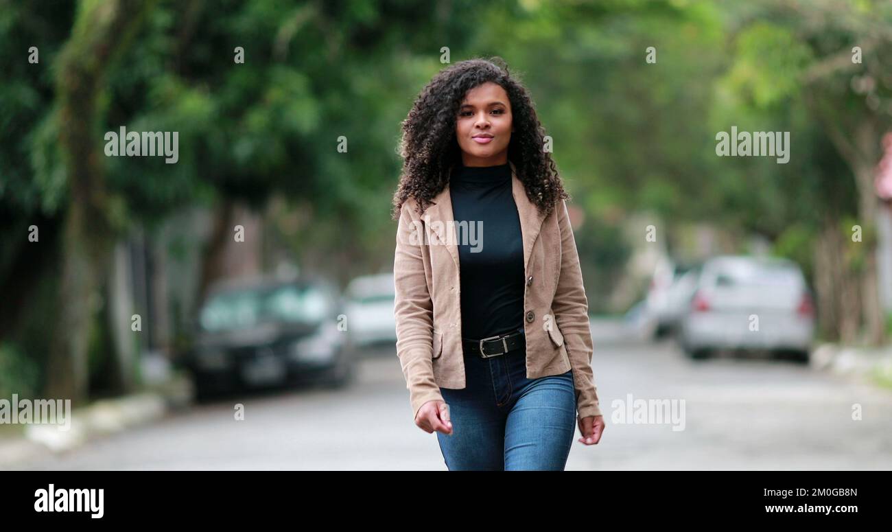 Confident black woman walking forward. Elegant millennial African ...